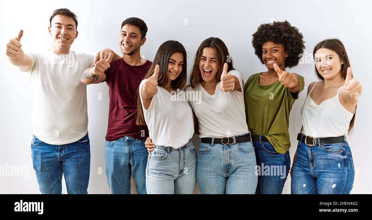 Group of young friends standing together over isolated background ...