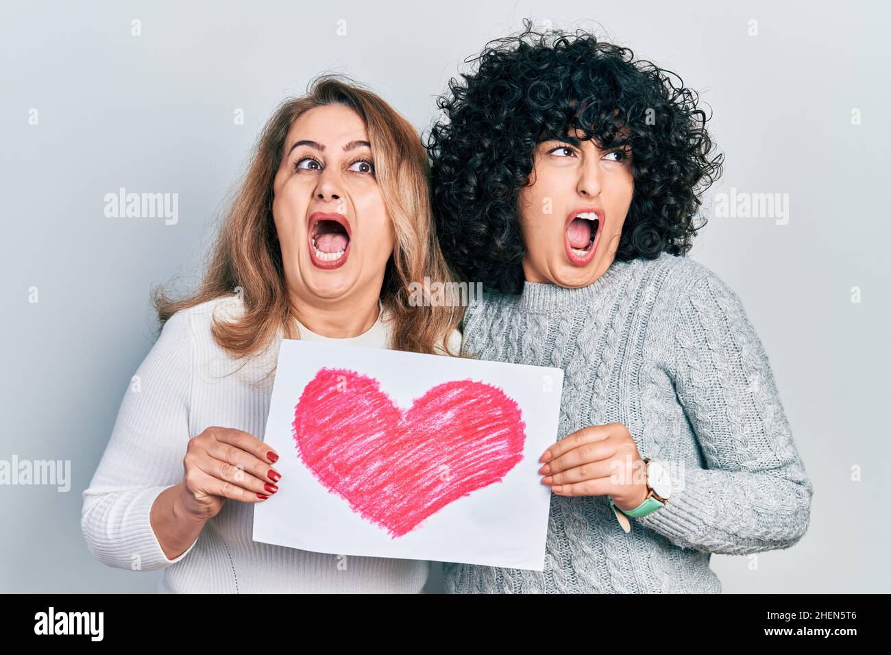 Middle east mother and daughter holding paper with heart draw angry and ...
