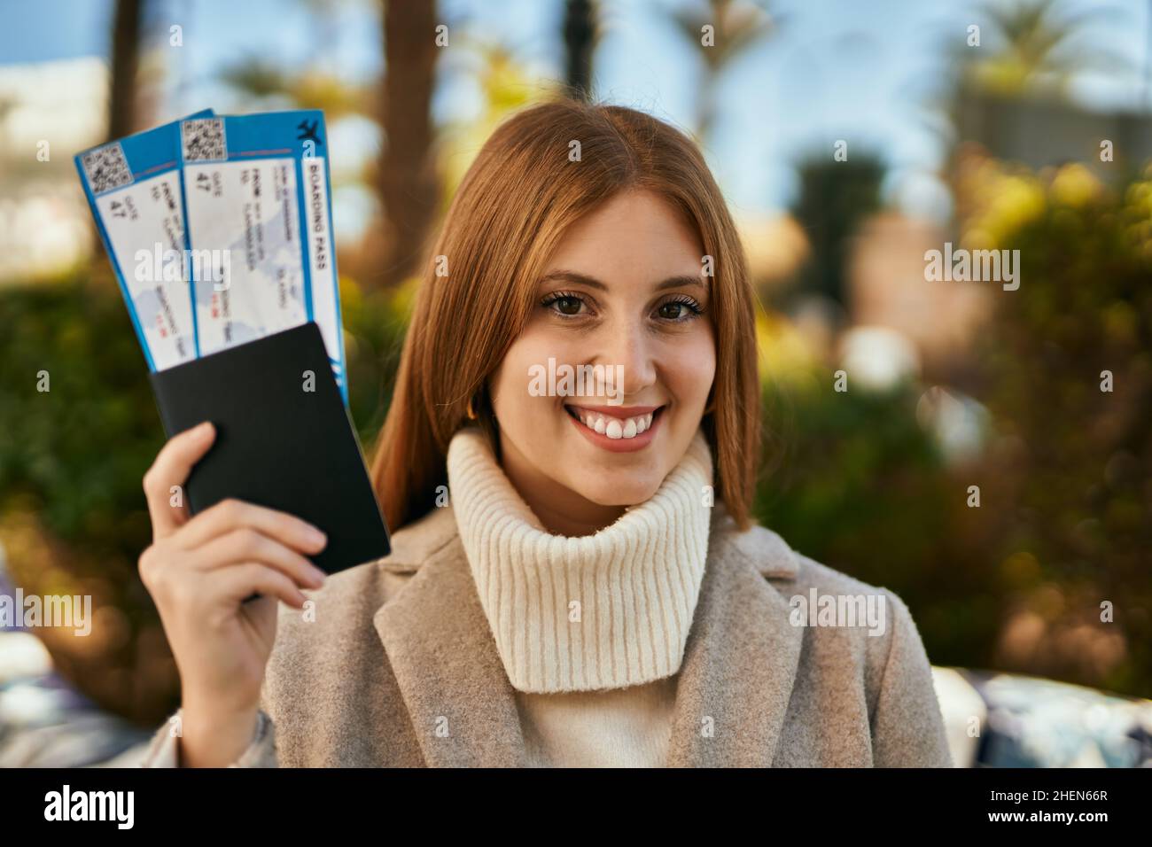 Young redhead girl smiling happy holding passport and boarding pass at ...