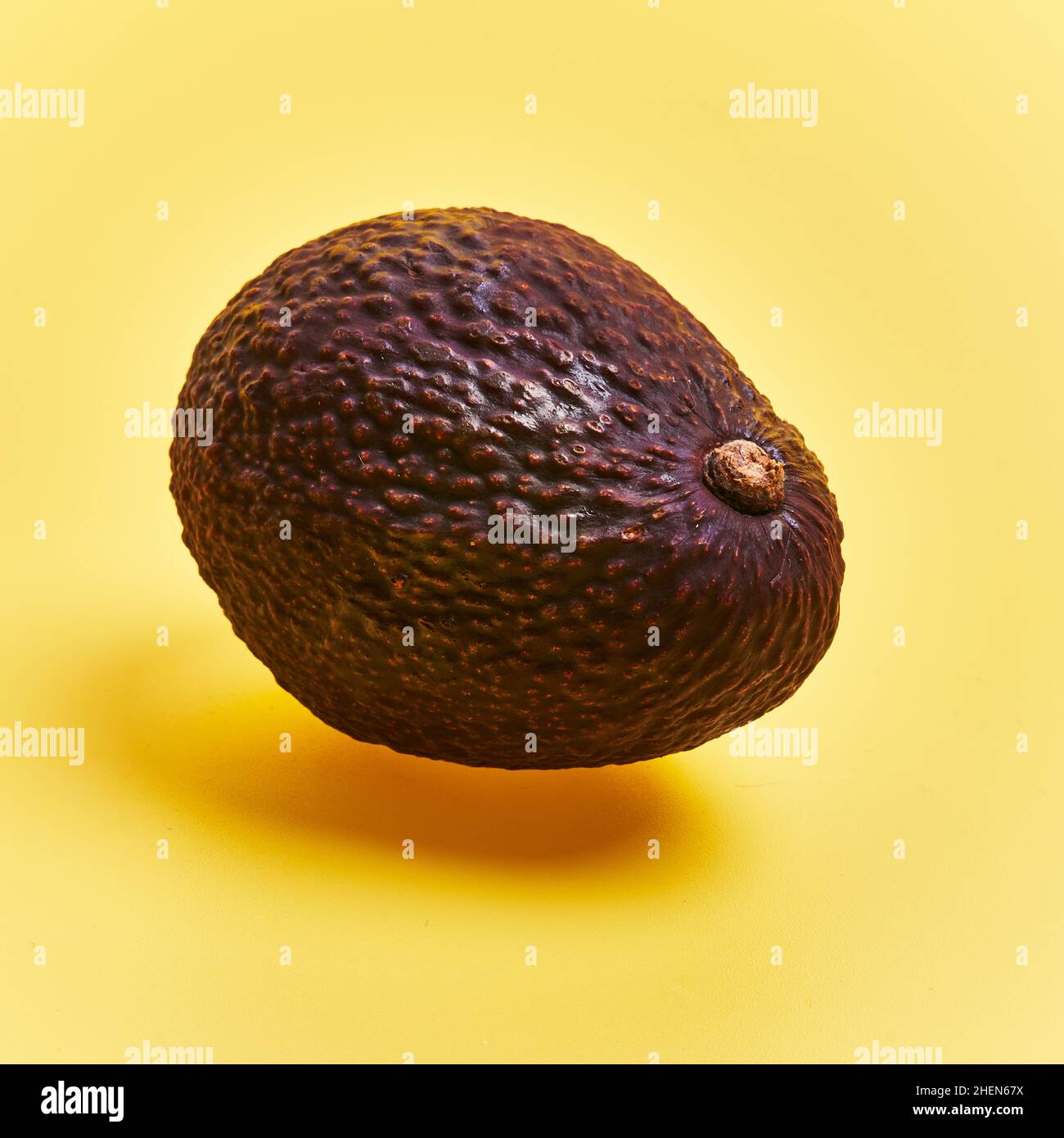SIngle avocado fruit over yellow background Stock Photo - Alamy