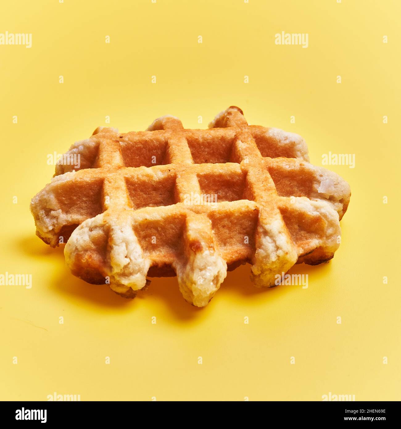 Single delicious waffle over yellow background Stock Photo - Alamy