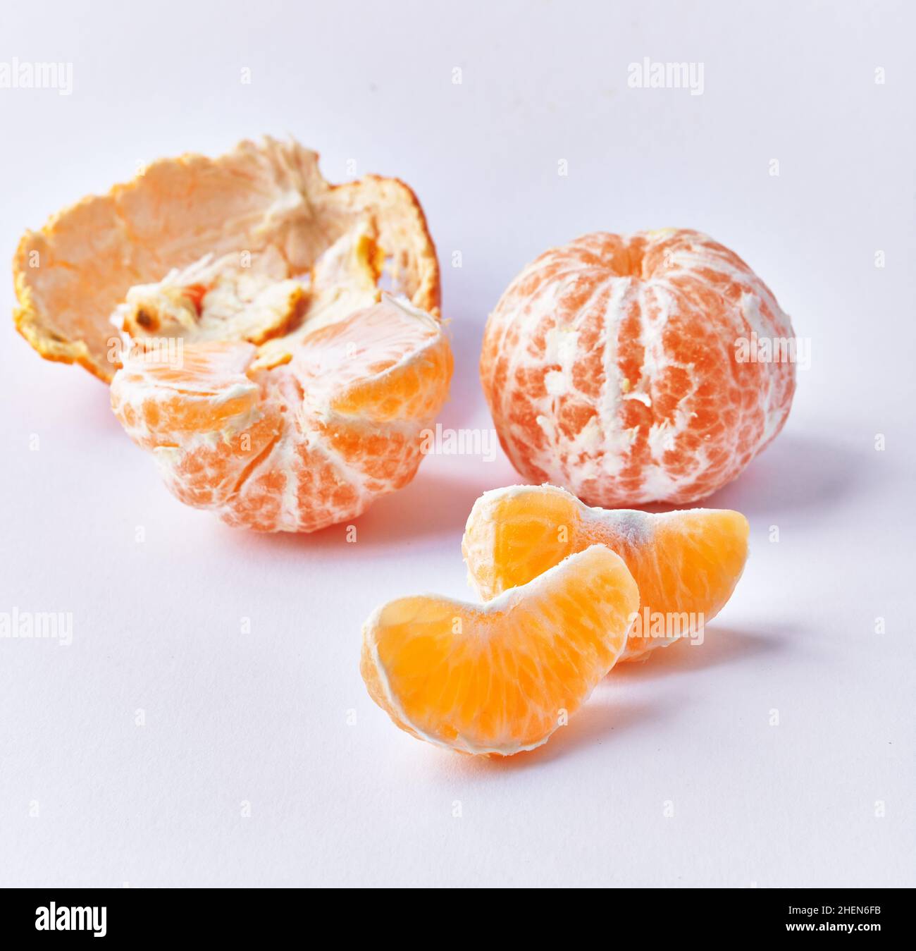 Two peeled tangerines isolated over white background Stock Photo - Alamy