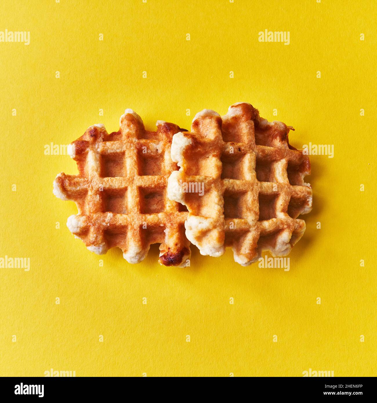 Two delicious waffles over yellow background Stock Photo - Alamy
