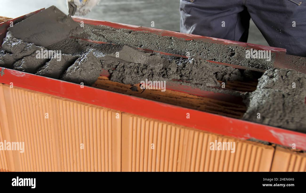 Close up of a bricklayer on a construction site with a trowel ...
