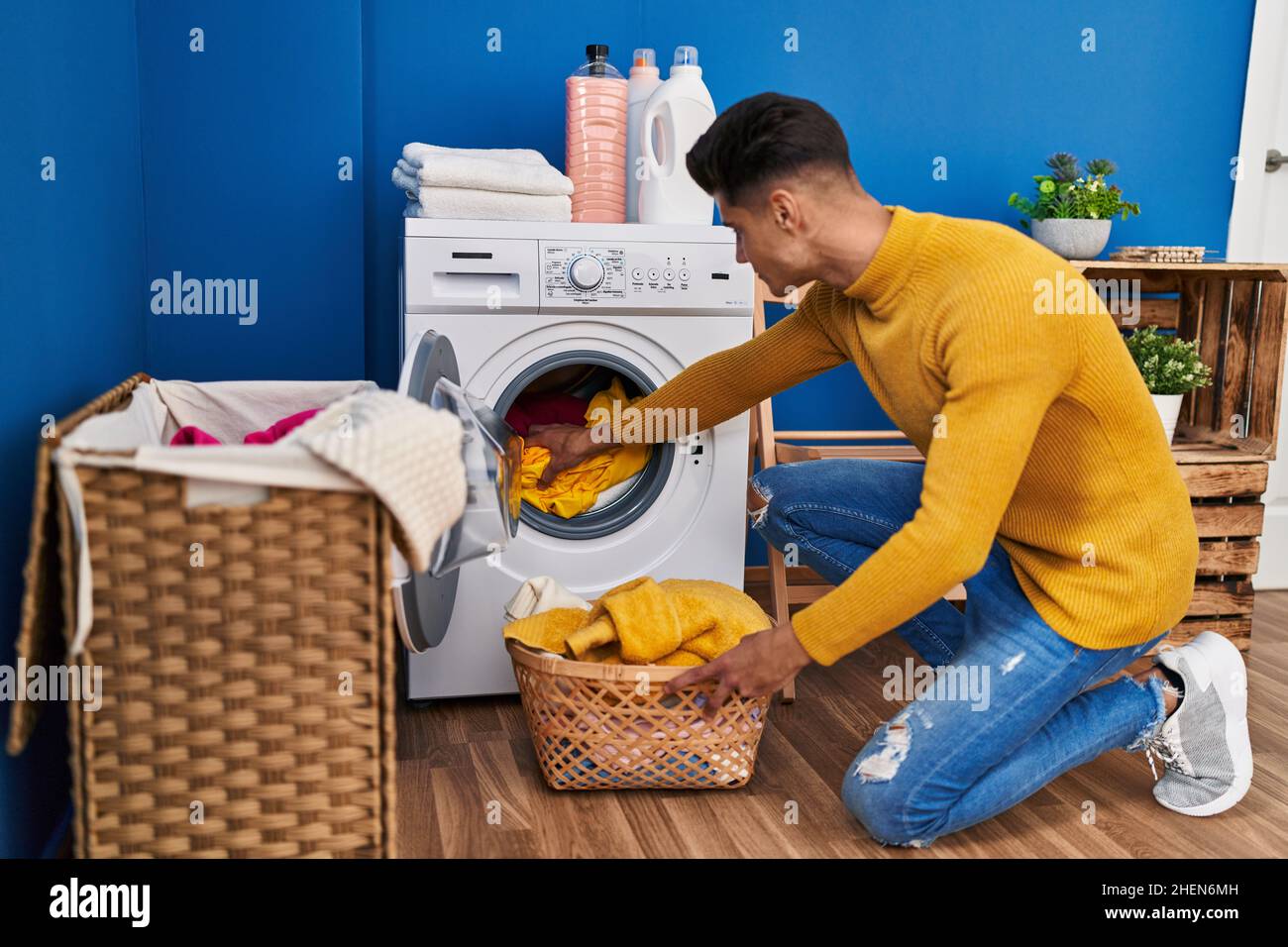 Young hispanic man washing clothes at laundry Stock Photo - Alamy
