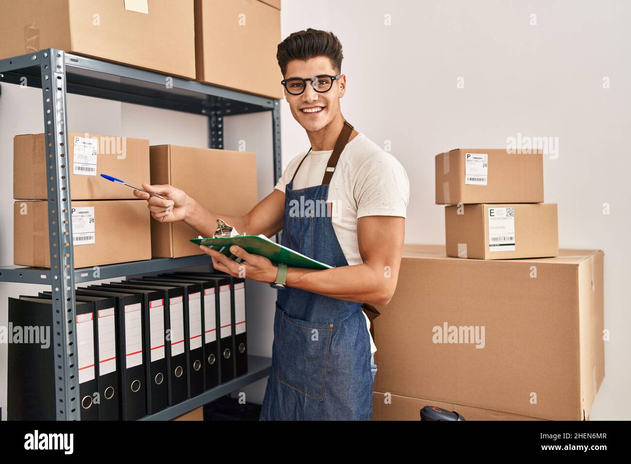 Young hispanic man ecommerce business worker organize packages at ...