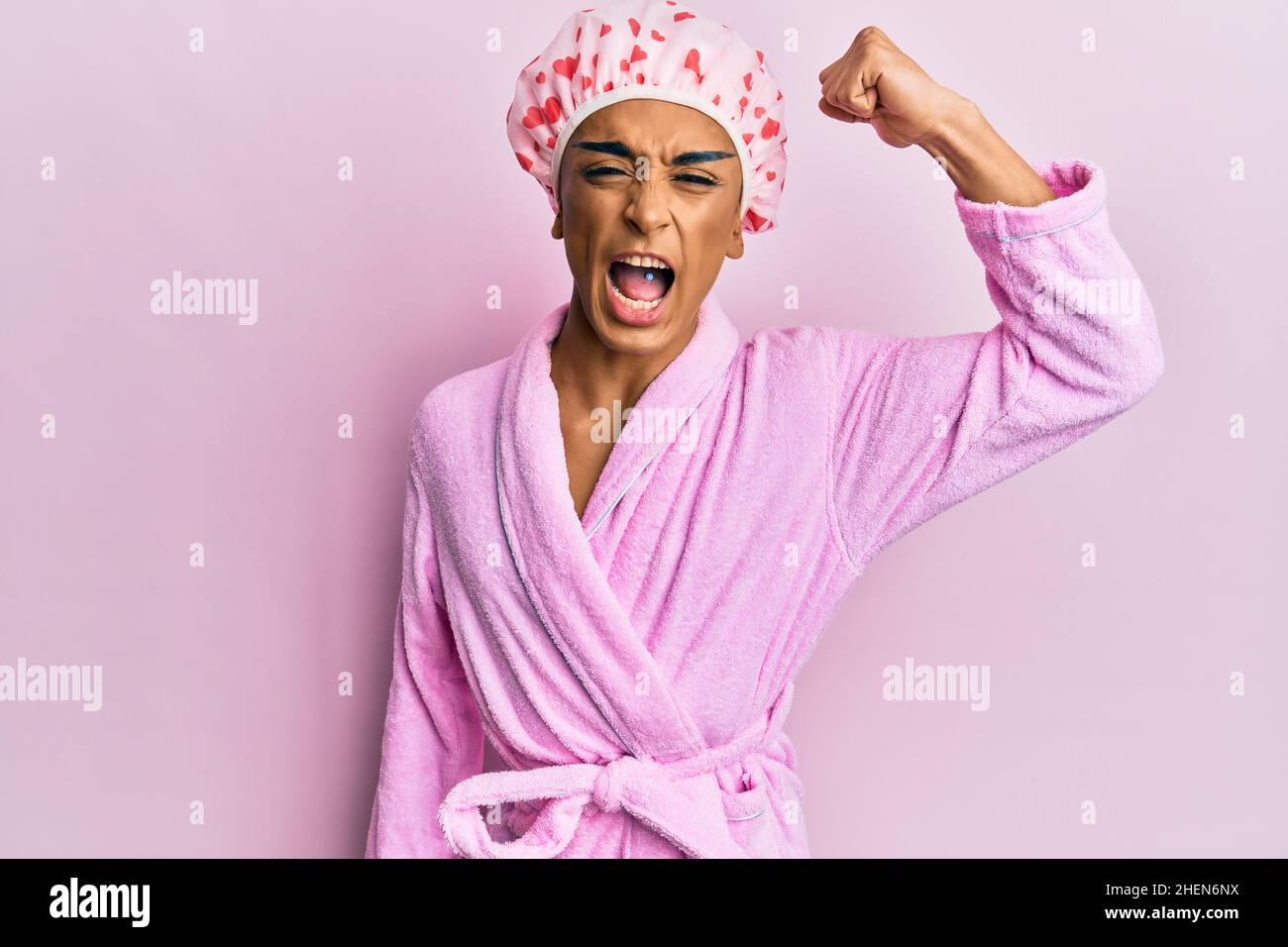 Hispanic man wearing make up wearing shower towel cap and bathrobe ...