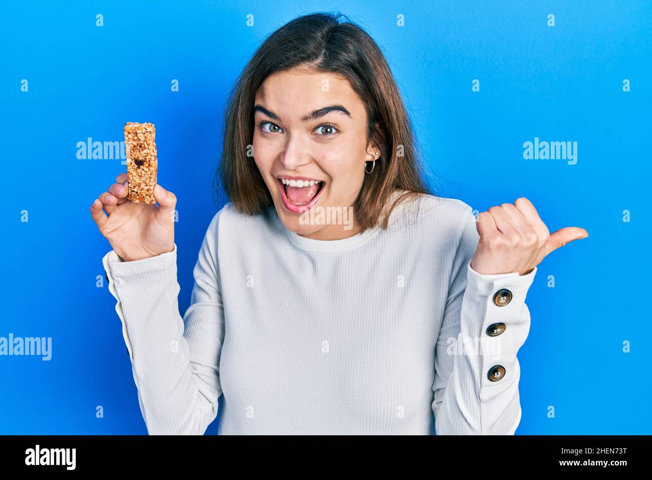 Young caucasian girl eating protein bar as healthy energy snack ...