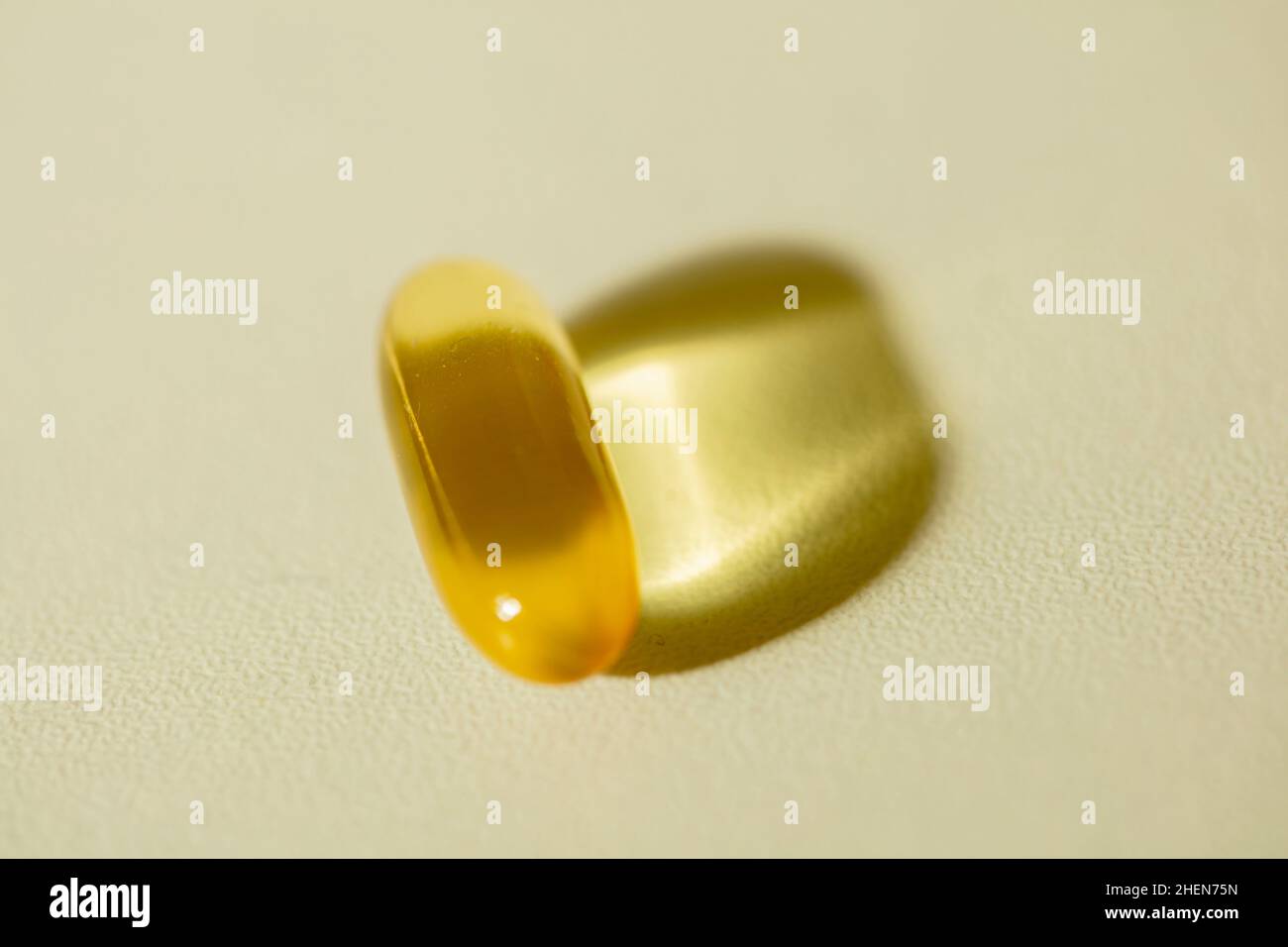 Very close-up medical still-life of Omega−3 capsule on plain background ...