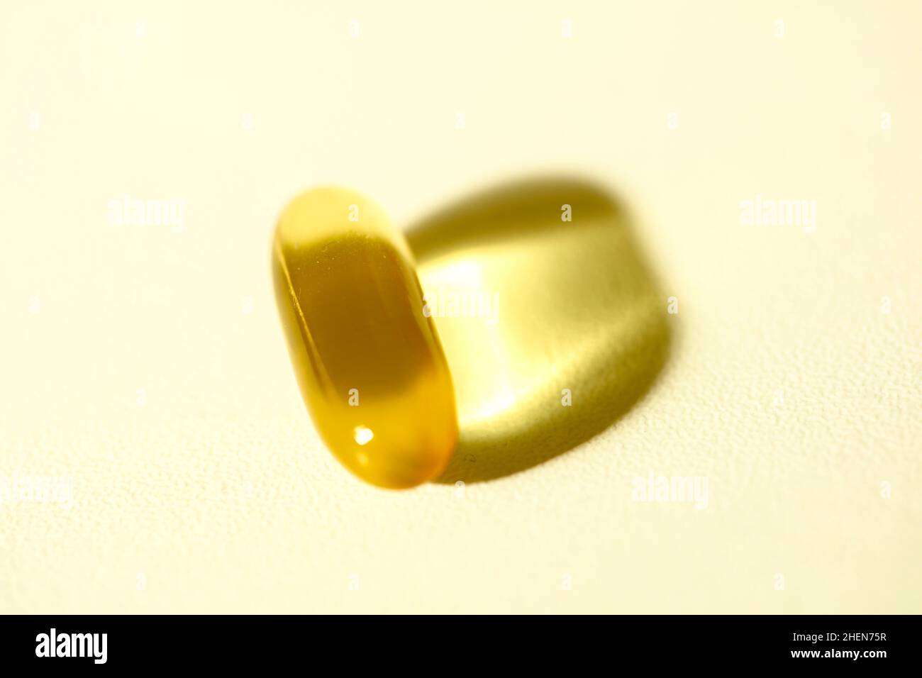 Very close-up medical still-life of Omega−3 capsule on plain background ...