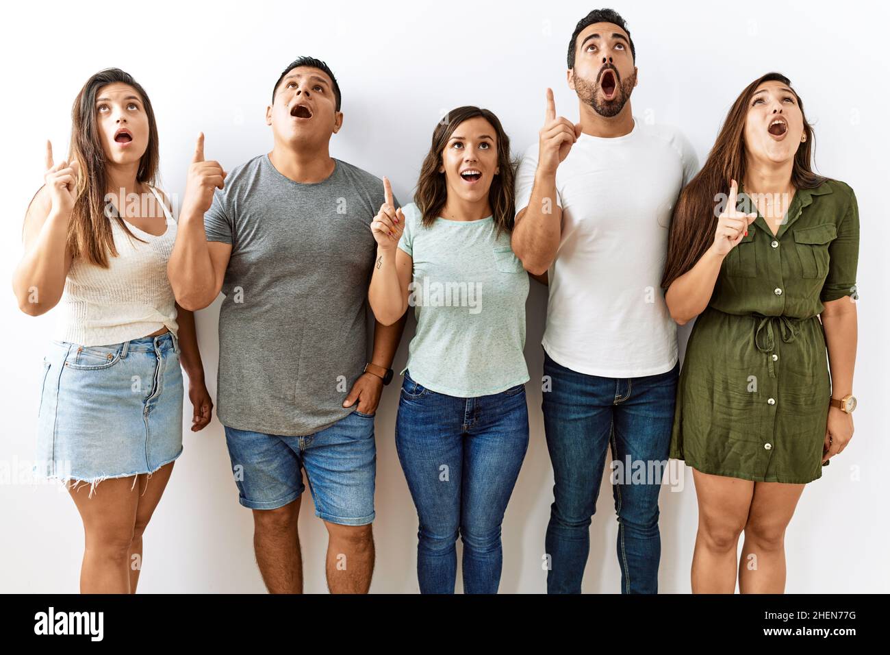 Group of young hispanic friends standing together over isolated ...