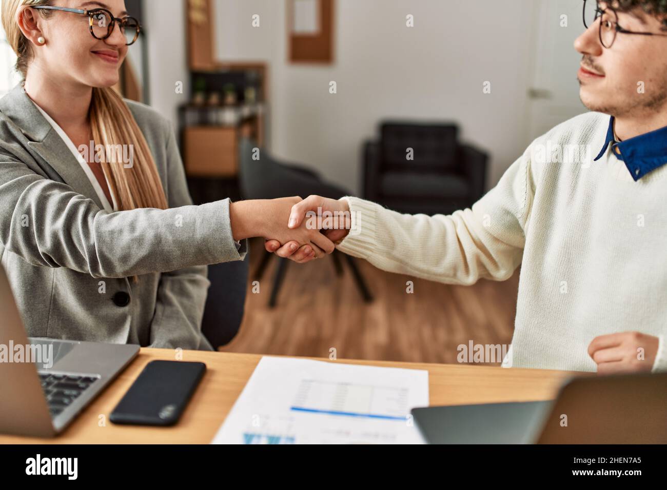 Two business executives shaking hands at the office Stock Photo - Alamy