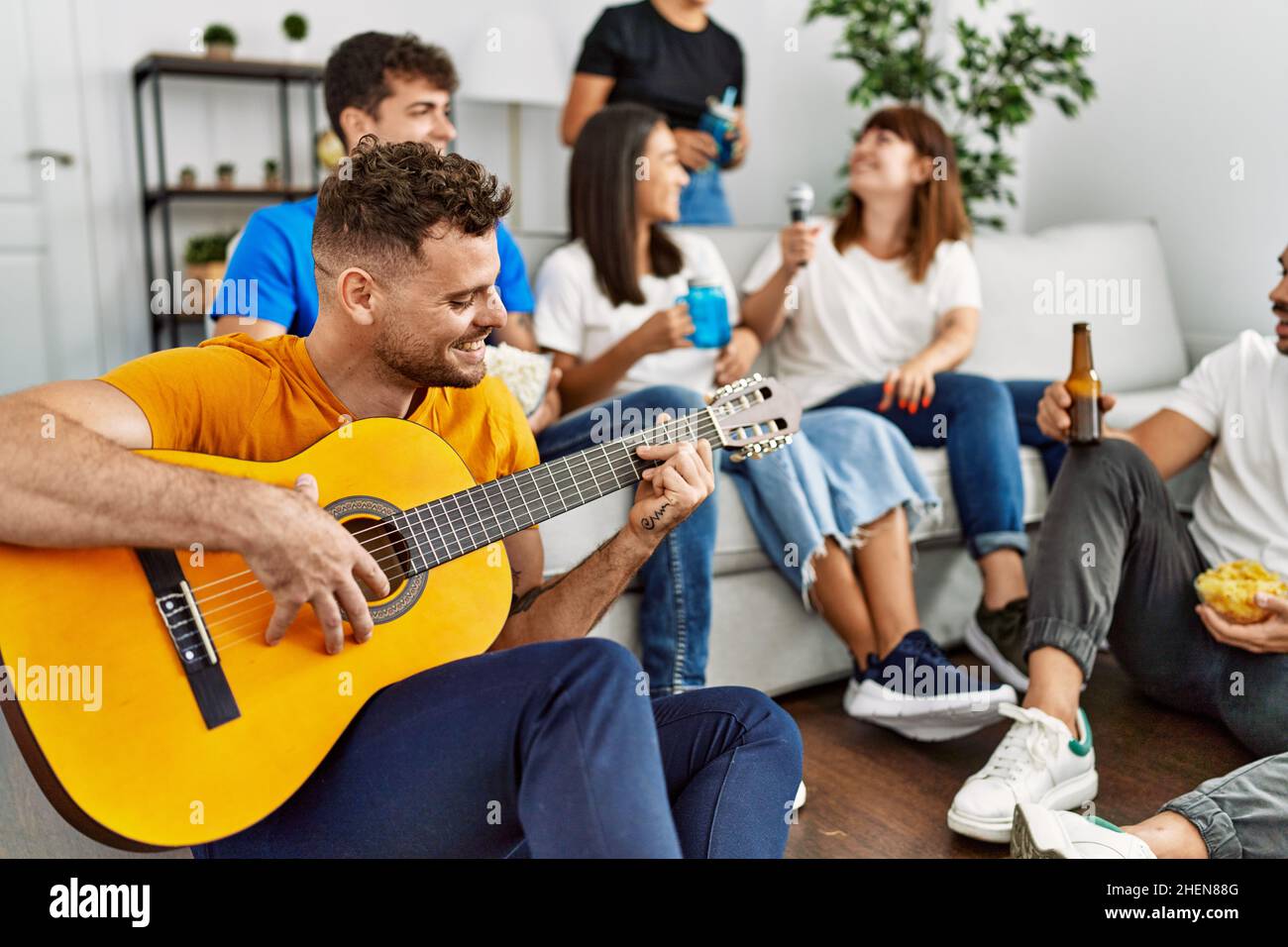 Group of young friends on party smiling happy and playing classical ...