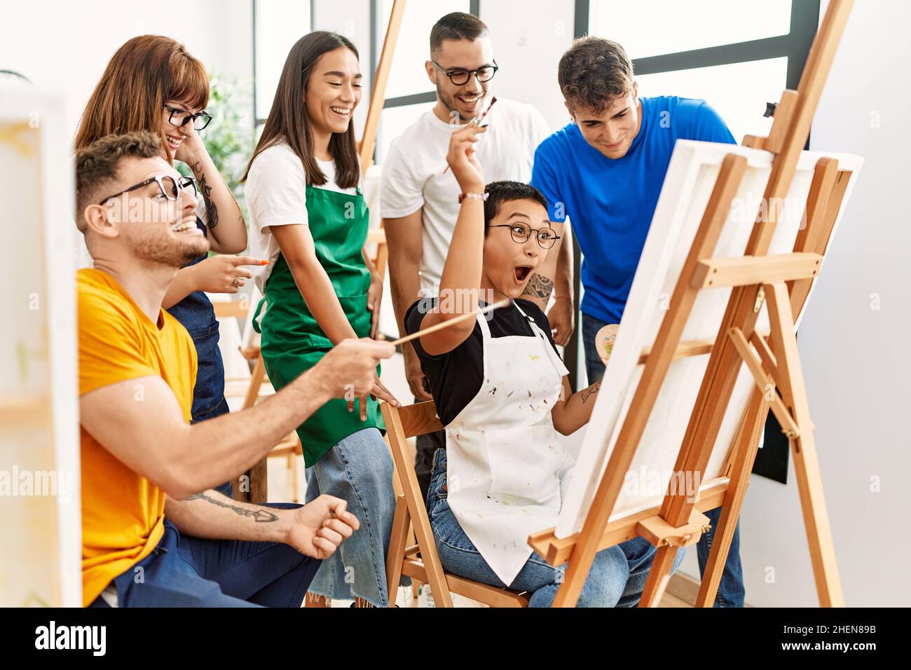 Group of people smiling happy and looking draw of partner at art studio ...