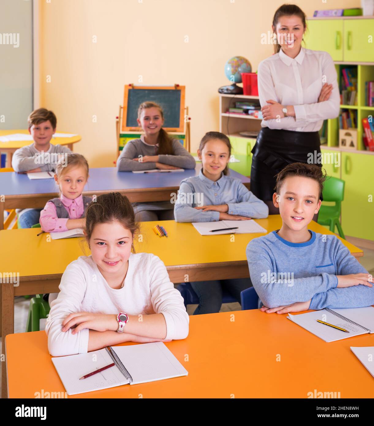 Teacher and children sitting at class Stock Photo - Alamy