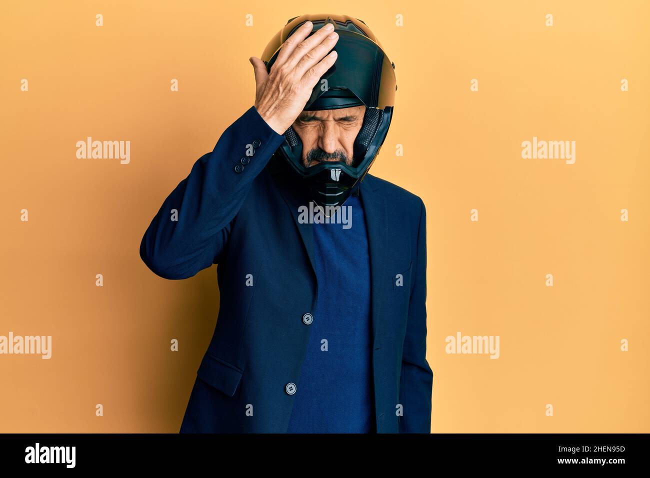 Middle age hispanic man wearing motorcycle helmet surprised with hand ...