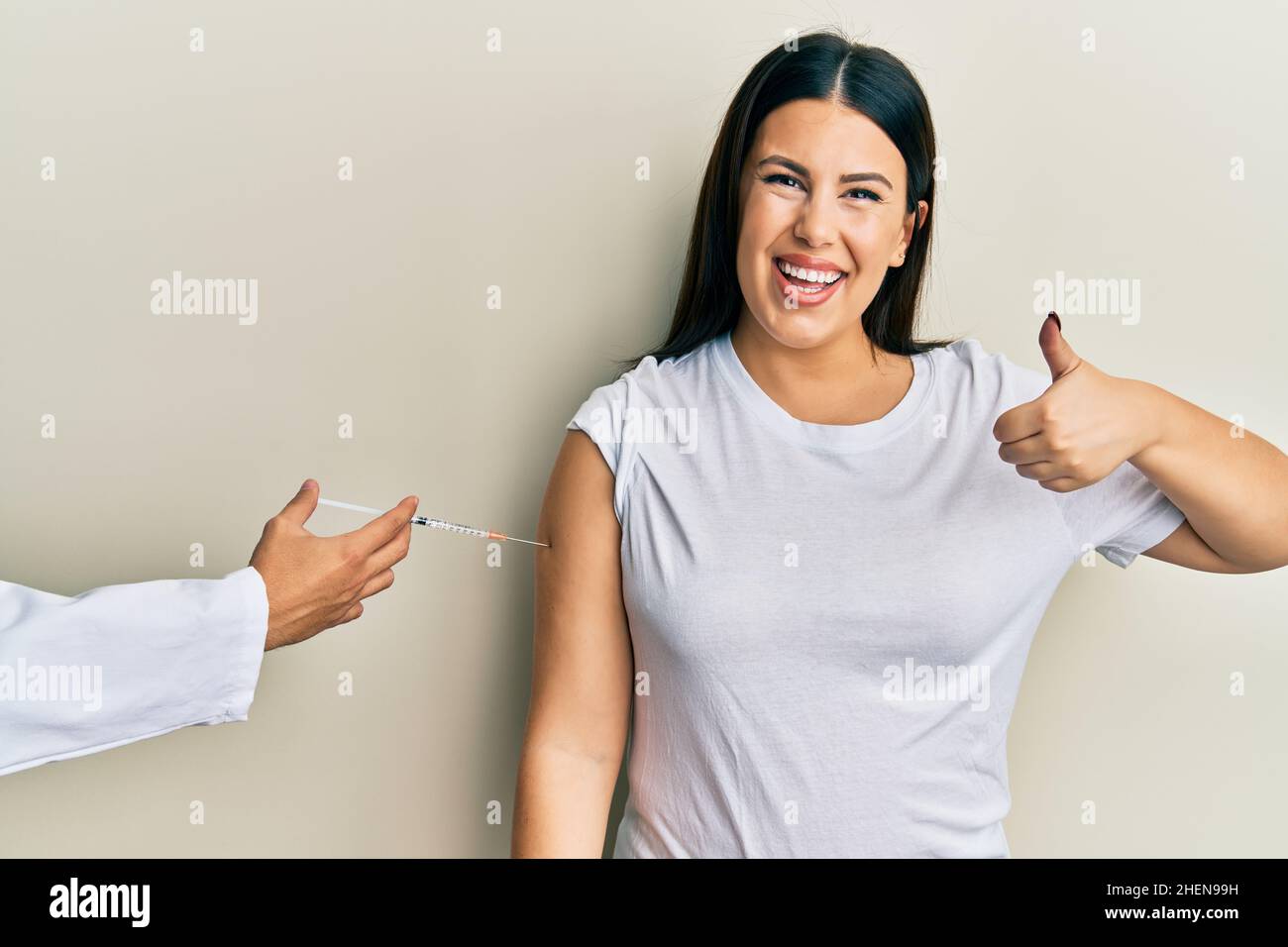 Beautiful brunette woman getting vaccine smiling happy and positive ...
