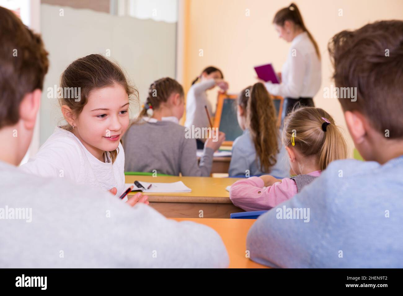 Elementary students chatting during class hi-res stock photography and ...