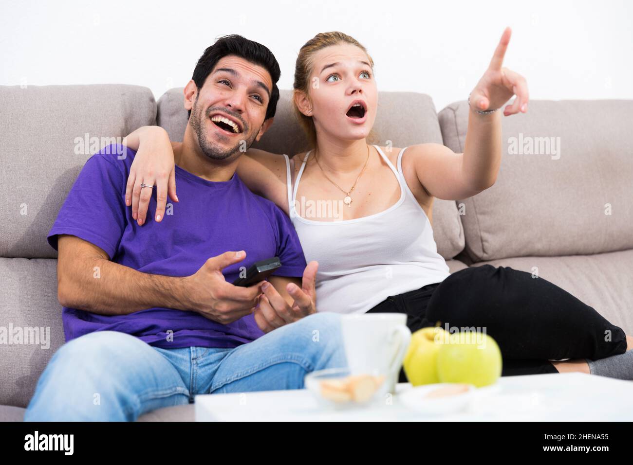 Happy couple watching TV at home Stock Photo - Alamy