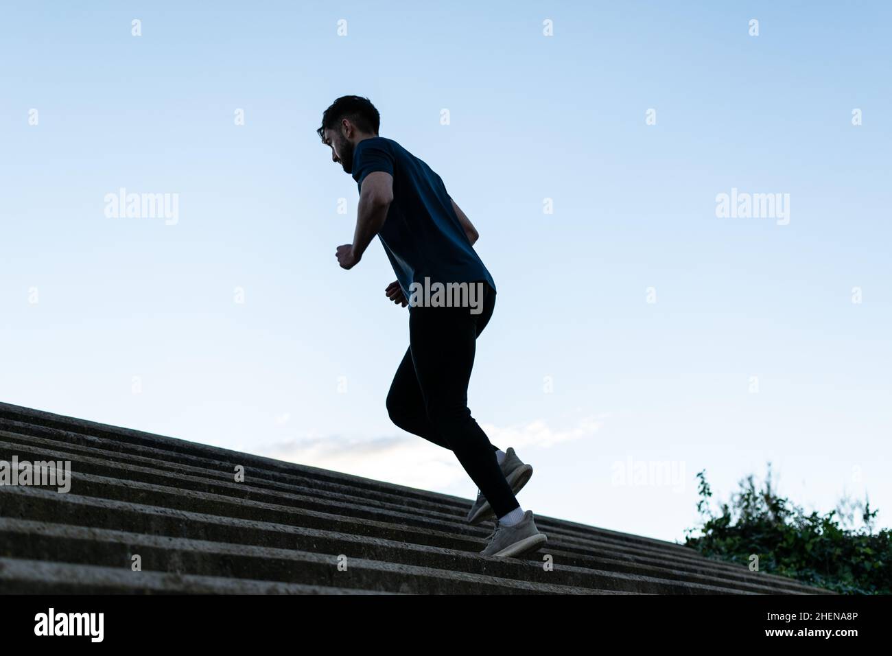 Unrecognizable young man running upstairs on city stairs Stock Photo ...