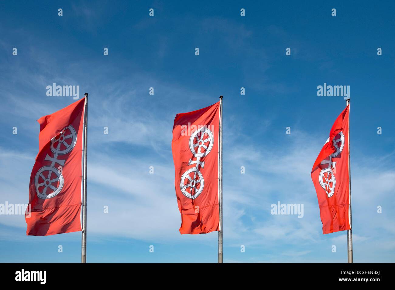 red flag with wheel as symbol for Mainz under blue sky Stock Photo - Alamy