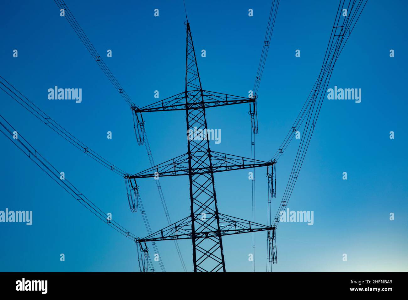 crossing electric pylon in sunset sky Stock Photo - Alamy