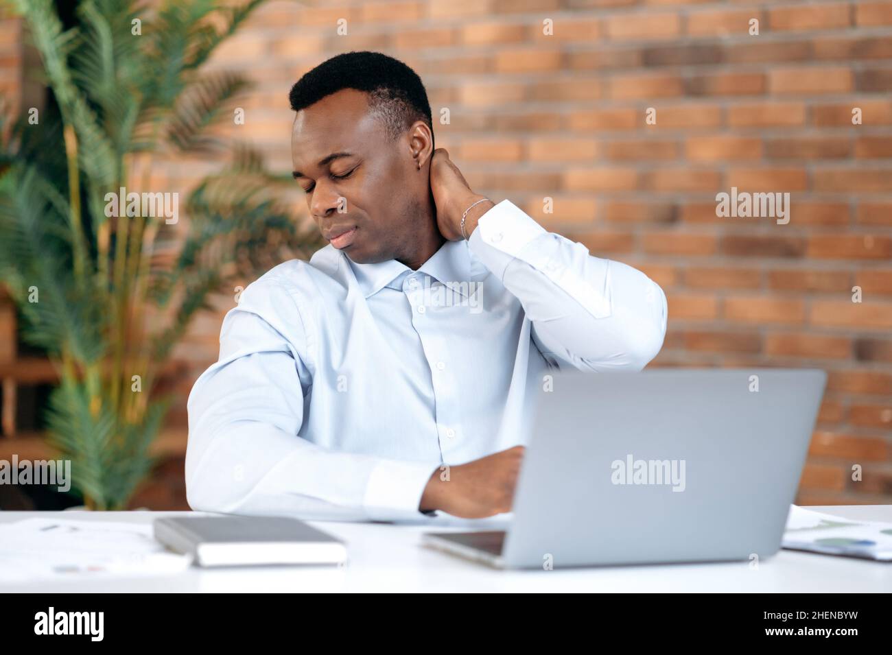 Overworked exhausted businessman, sales manager, sitting at a desk in ...