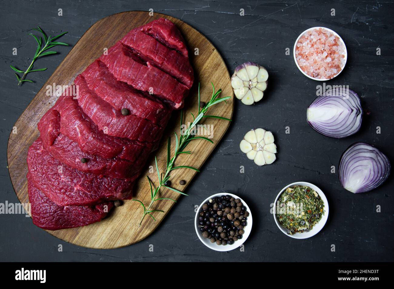 A peace of raw meat on black stone background, top view Stock Photo - Alamy