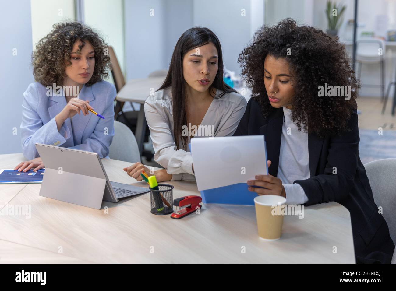 Multicultural business women having a reunion in the office and talking ...