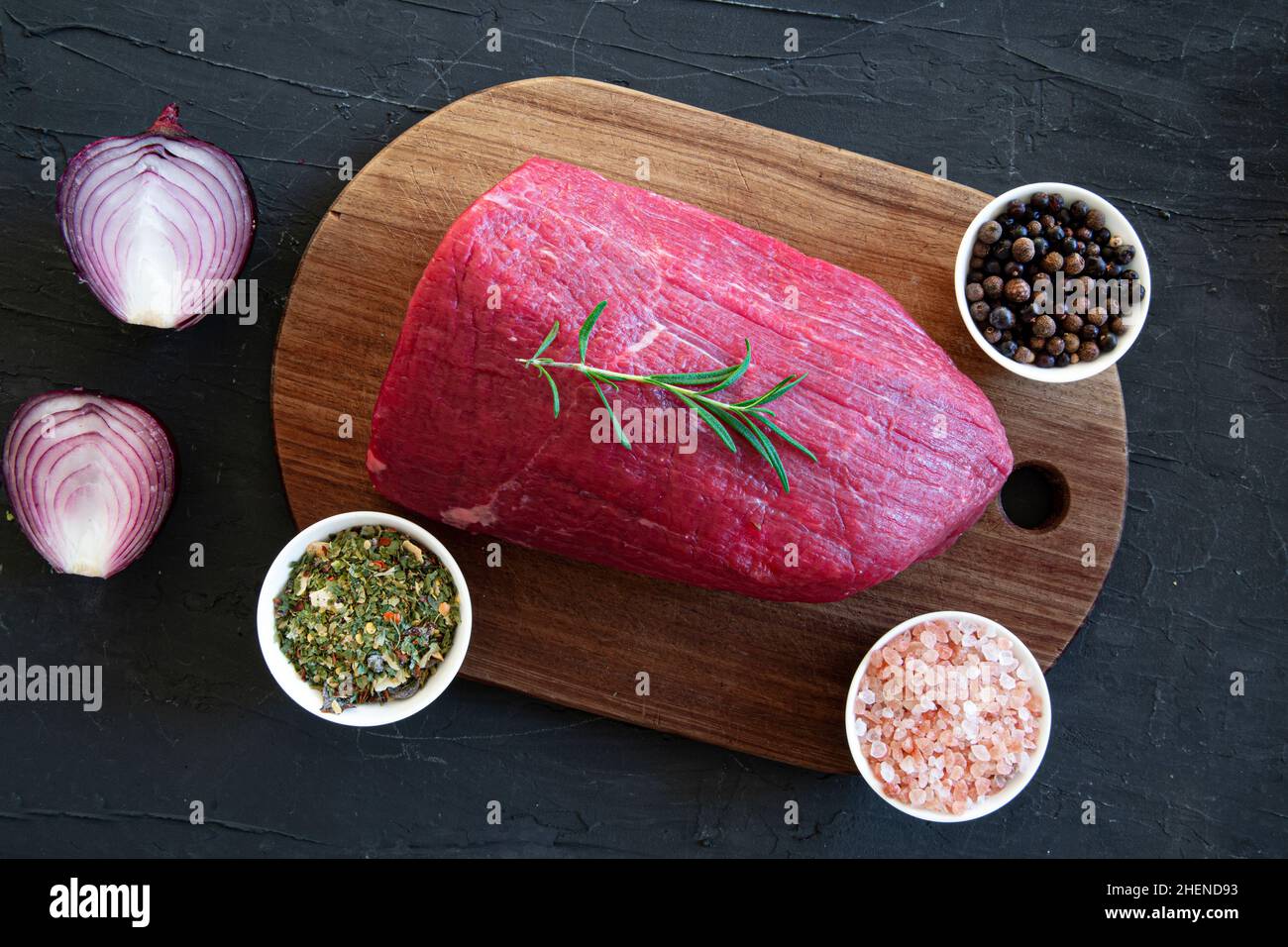 A big red piece of natural beef meat, concrete stone black background ...
