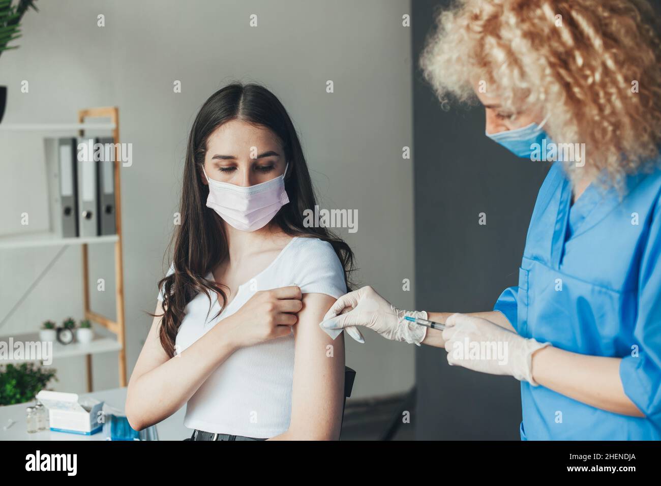 Medical nurse is making a vaccine injection to a patient in a health ...