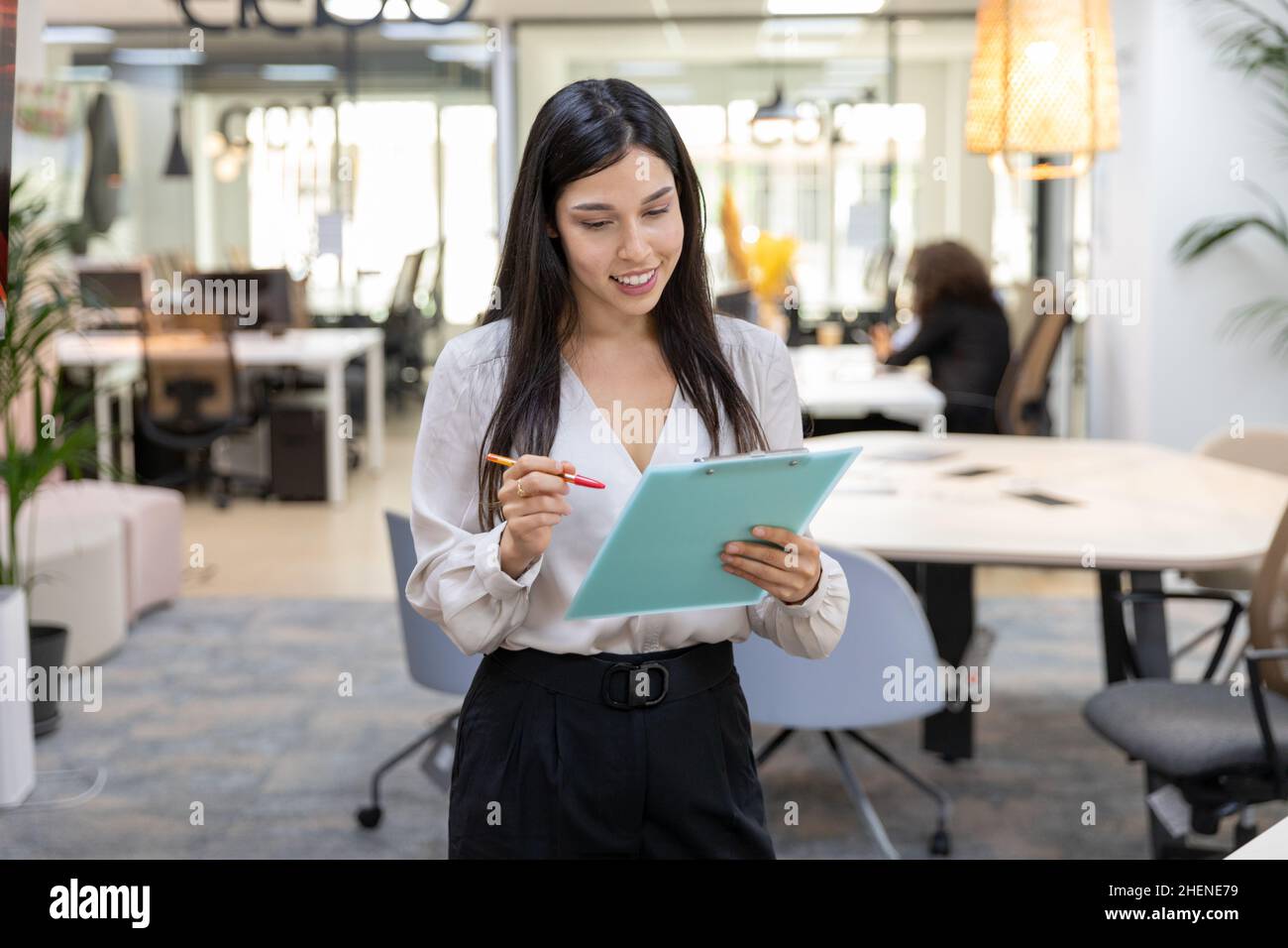 Young business woman wearing formal clothes standing in the office and ...