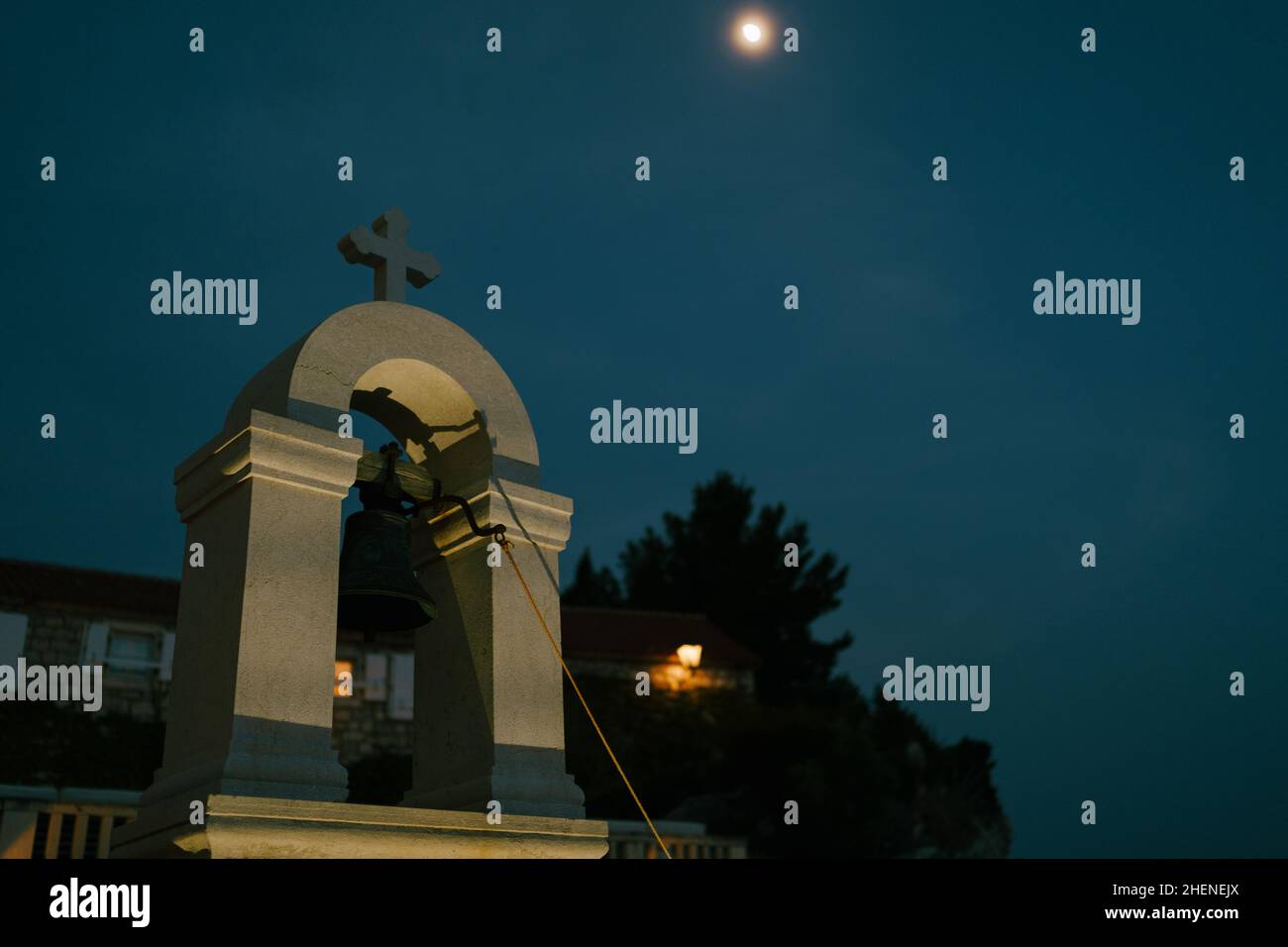 Bell on the bell tower against the background of the moon in the sky ...
