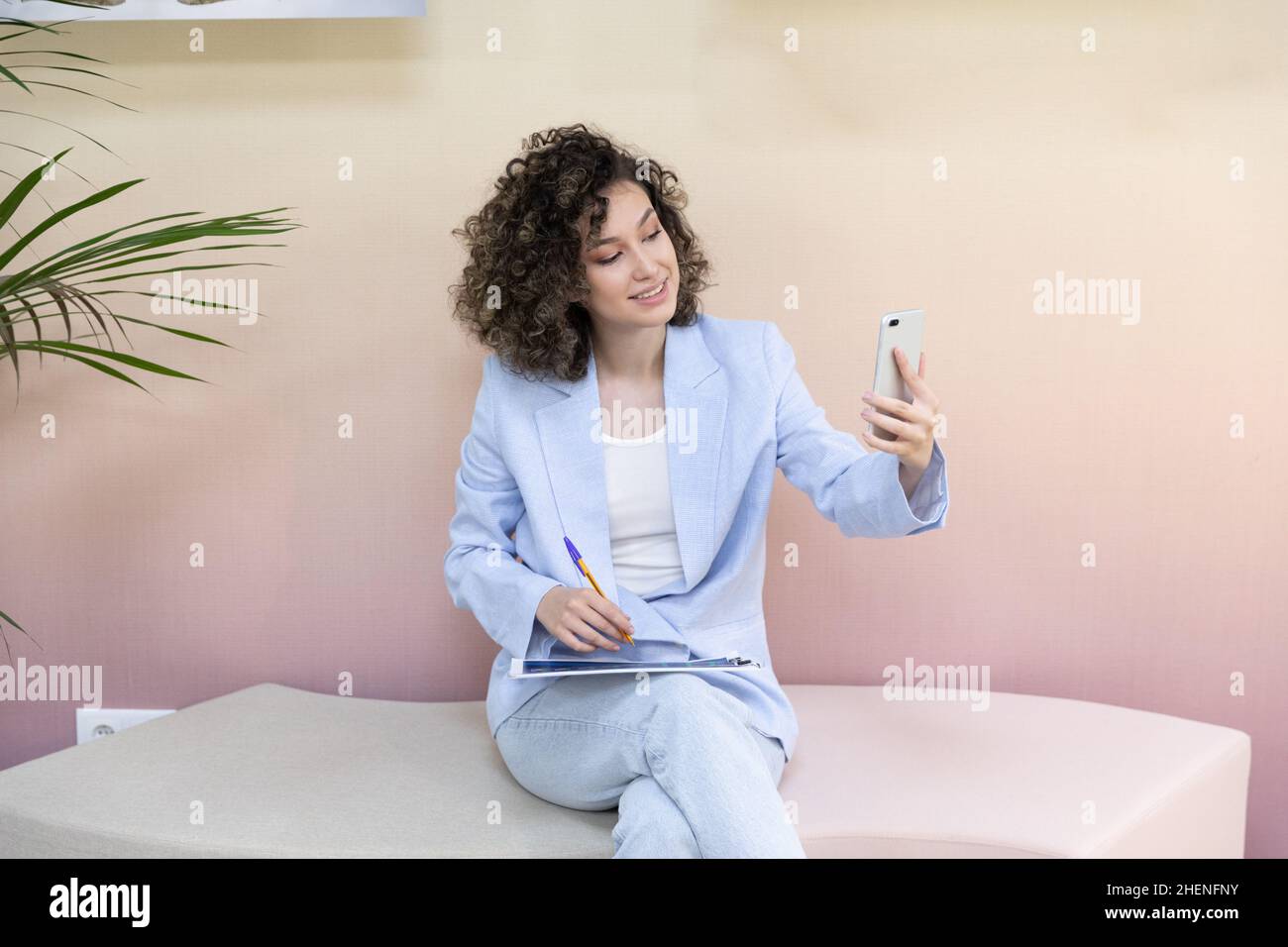 Happy female office worker sitting in a couch smiling and taking a ...