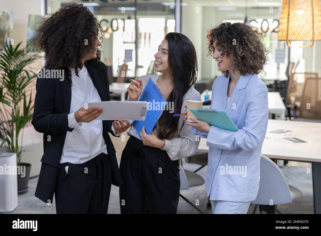 Multicultural coworkers working in the office and having a conversation ...