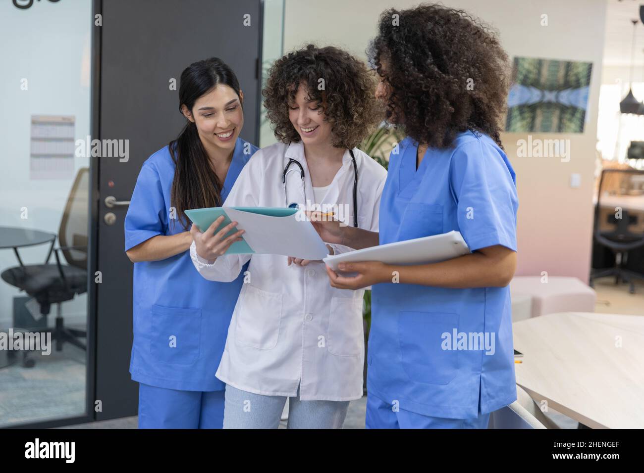 Young female medical work team wearing blue uniform smiling and looking ...