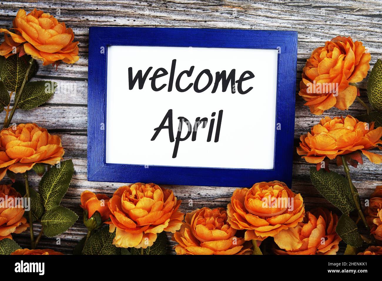 Welcome April text in blue border frame with flower decoration on ...