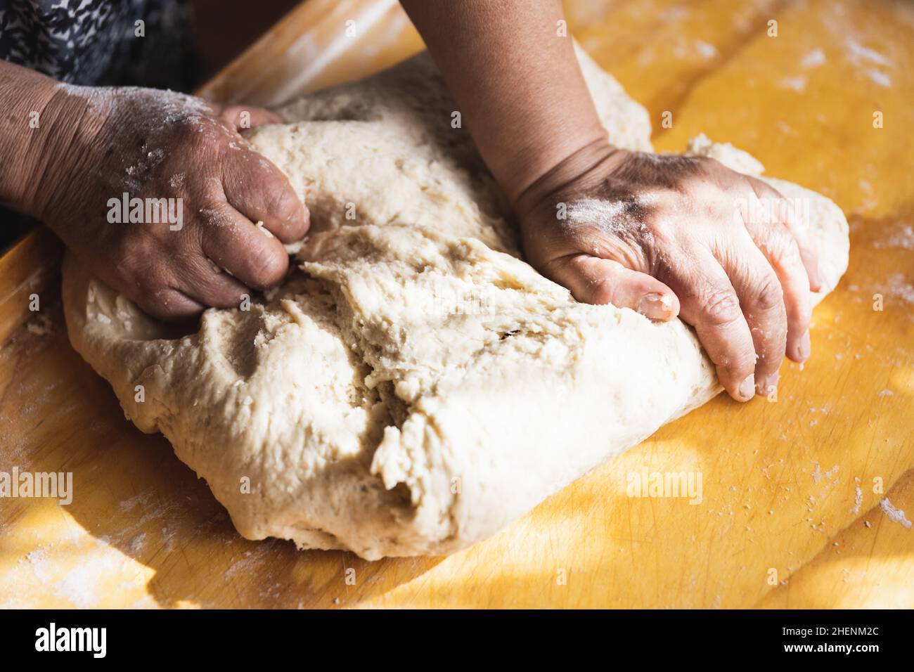 Old woman's hands kneading bread dough. Empanadas. Wooden table Stock ...
