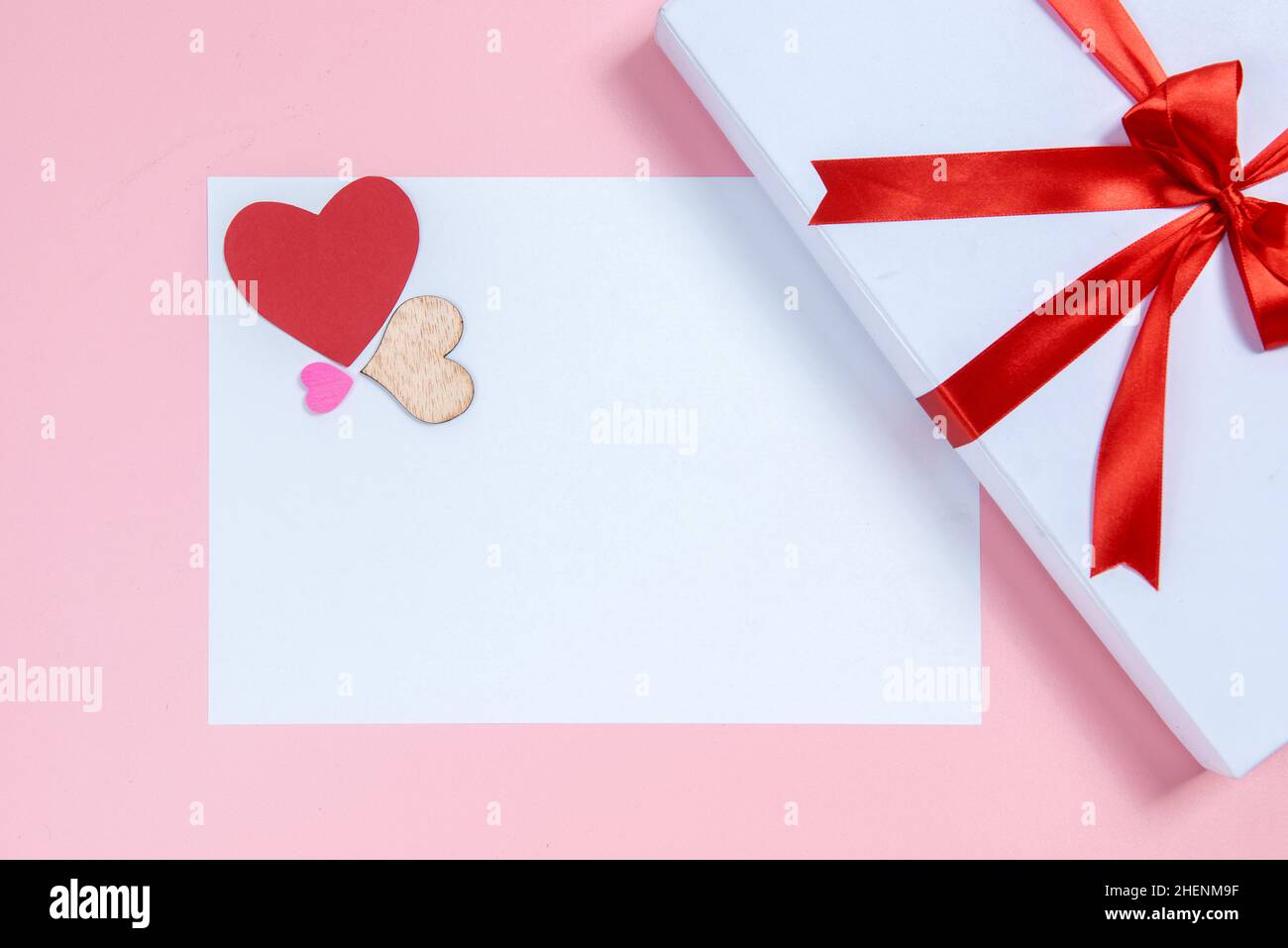 Empty white paper with heart and gift box with a colored background ...