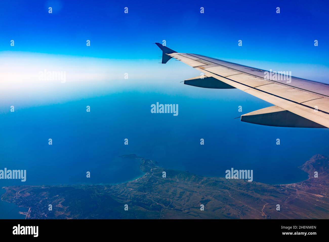 View from the airplane window at a beautiful blue clear sky, earth, sea ...