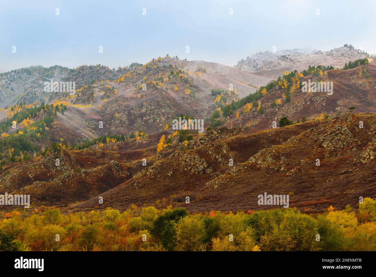 Picturesque autumn mountain landscape. At foot of mountain range is a ...