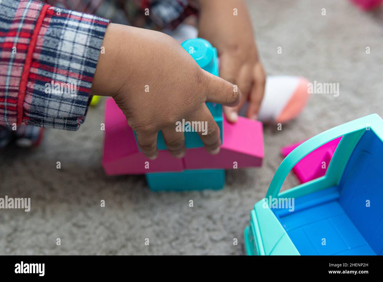 Child playing with bricks at home to construct a toy Stock Photo - Alamy