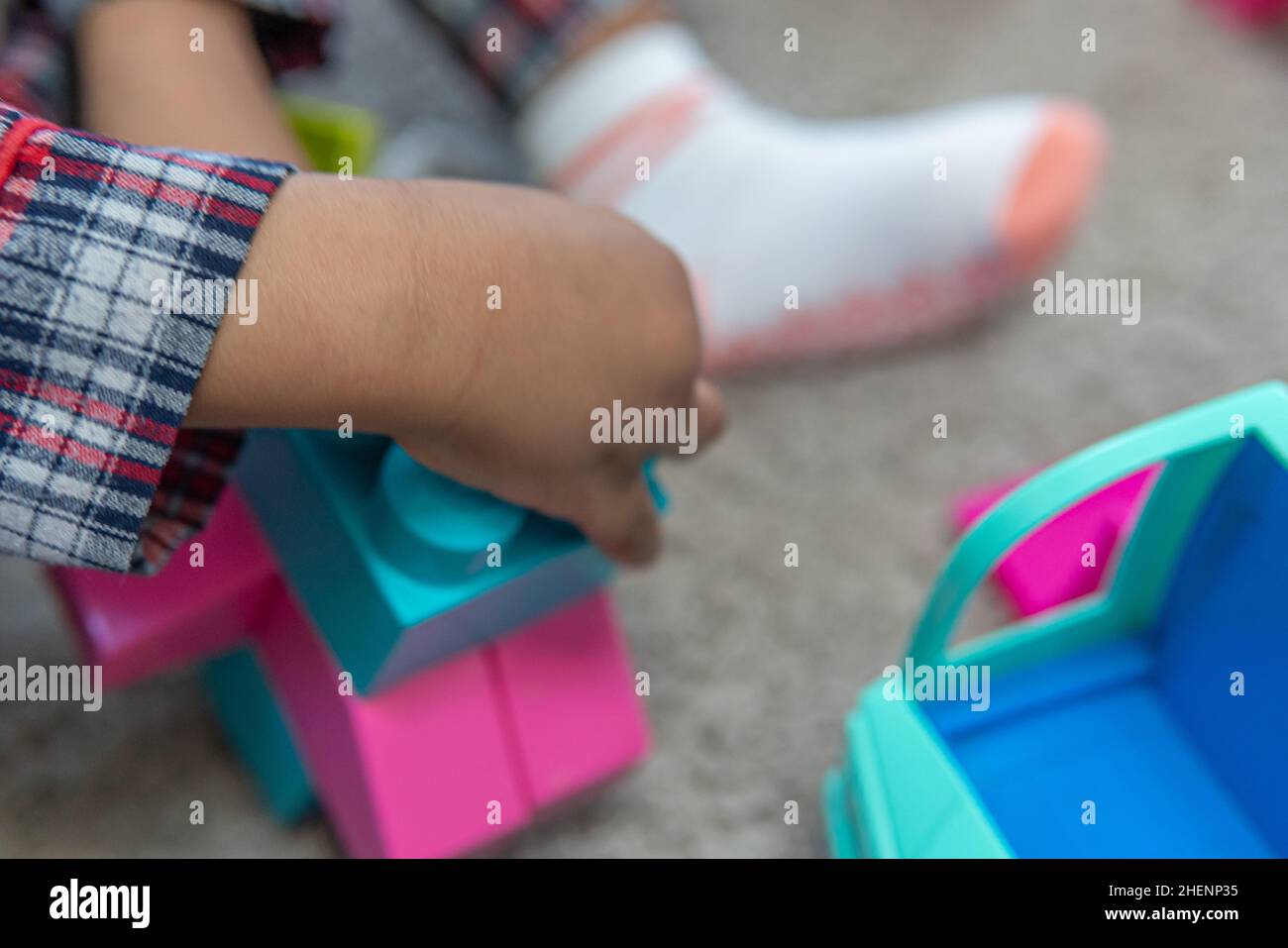 Child playing with bricks at home to construct a toy Stock Photo - Alamy