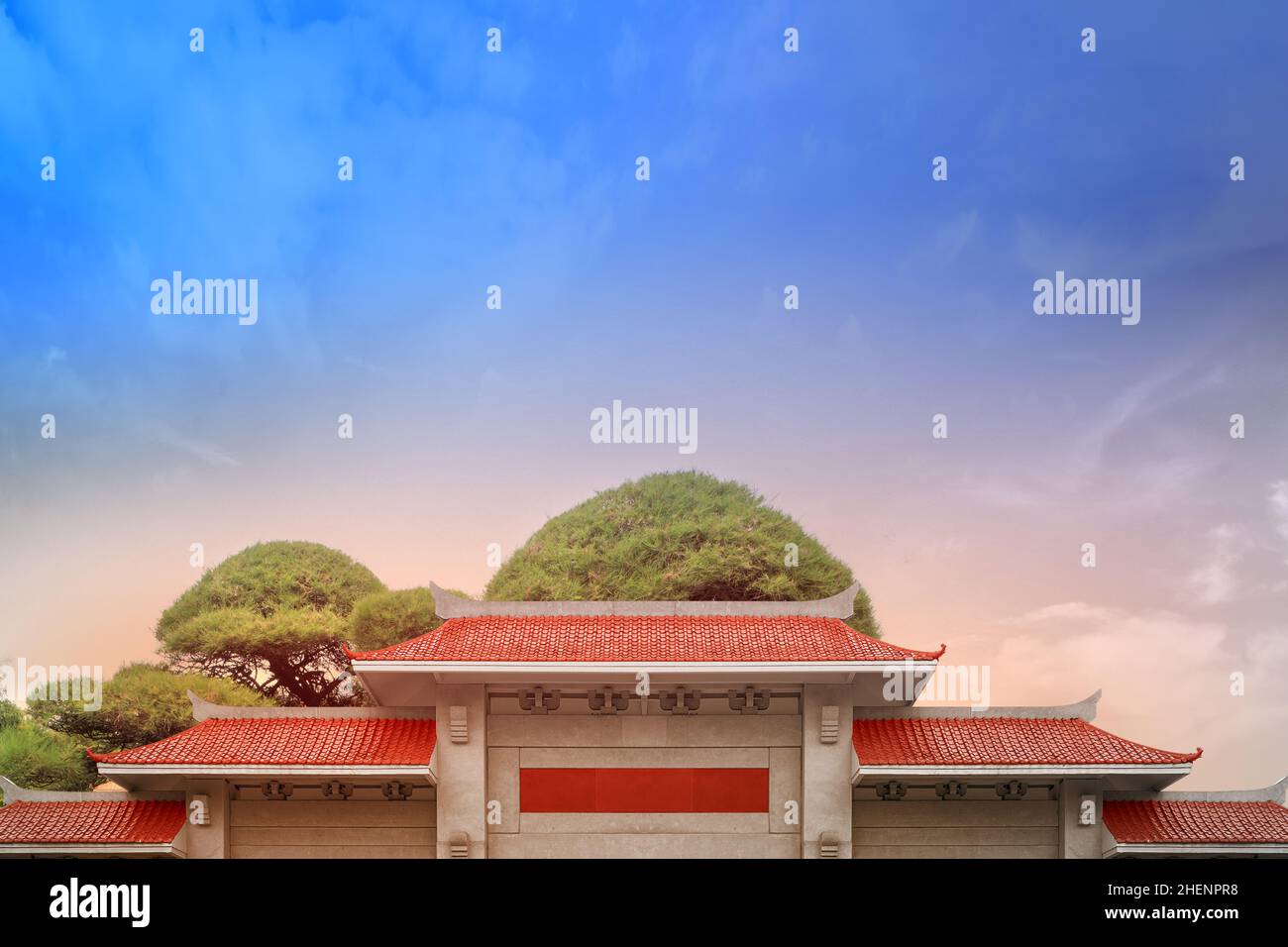 Chinese pavilion gate with red roof with garden view and a dramatic sky ...