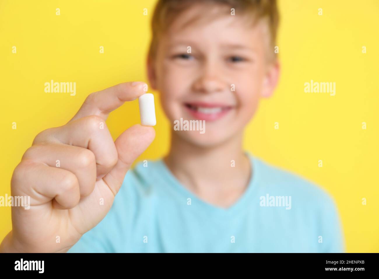 Little boy with chewing gum on yellow background, closeup Stock Photo ...