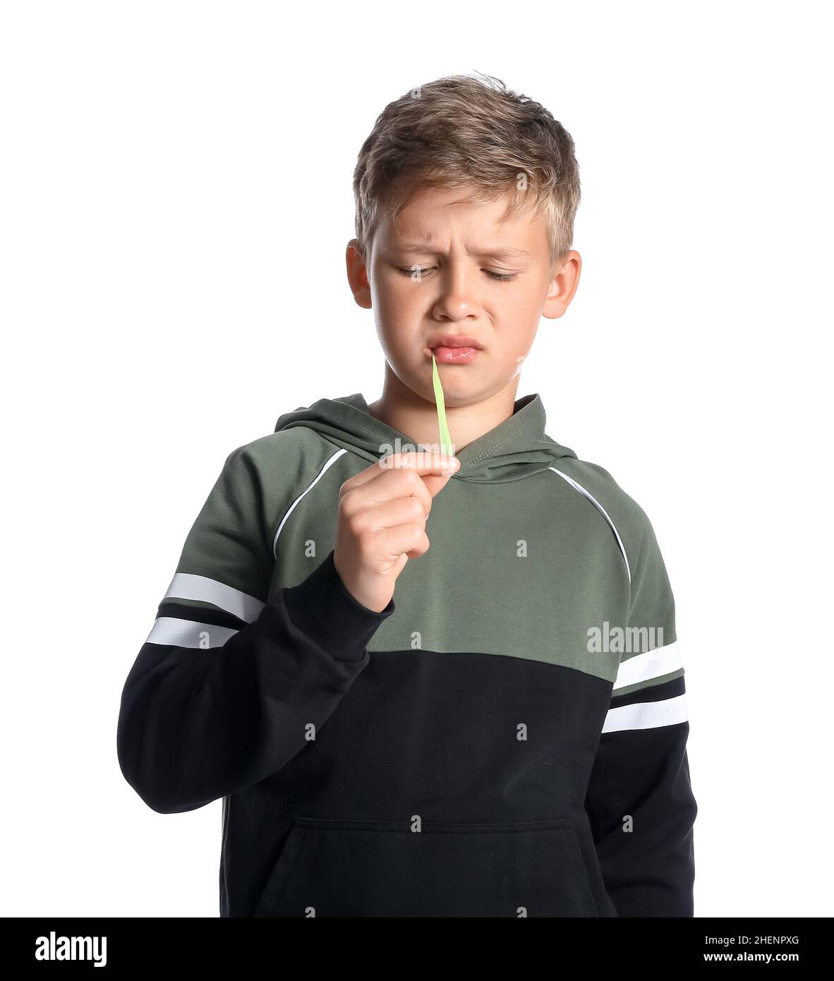 Displeased little boy in hoodie chewing gum on white background Stock ...
