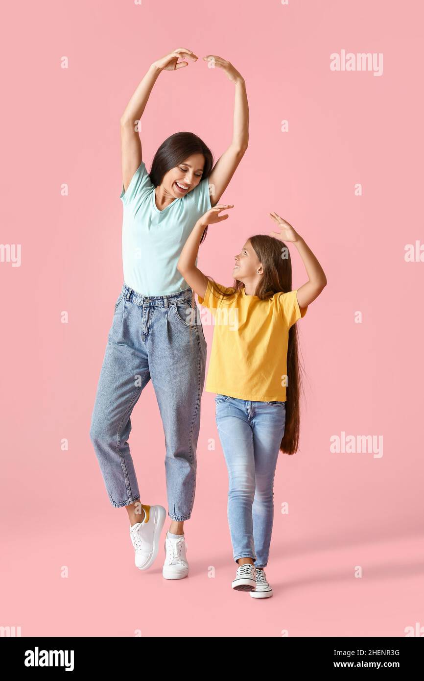 Happy dancing woman and her daughter on color background Stock Photo ...