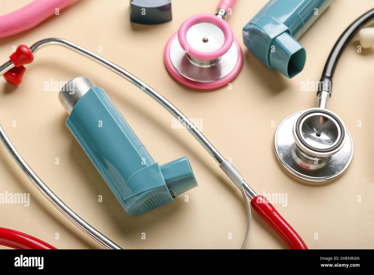 Asthma inhalers and stethoscopes on beige background, closeup Stock ...