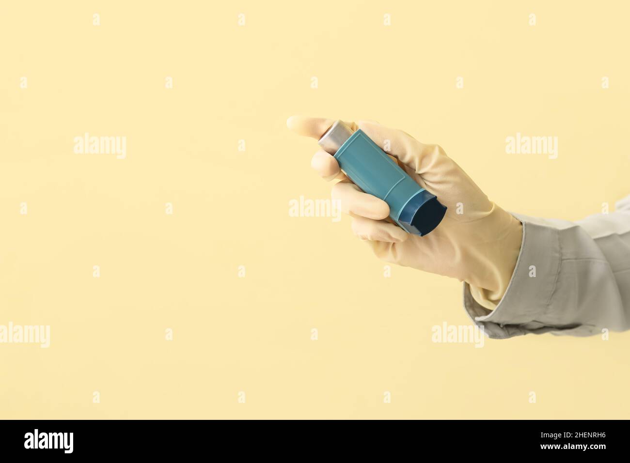 Woman holding asthma inhaler on beige background Stock Photo - Alamy