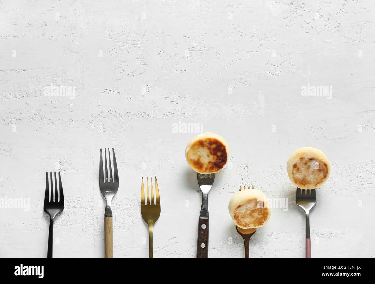 Forks with tasty cottage cheese pancakes on white background Stock ...